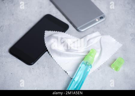 Cleaning the smartphone with soft cloth and alcohol. COVID-19 ...