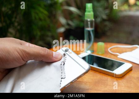 Cleaning the smartphone with soft cloth and alcohol. COVID-19 ...