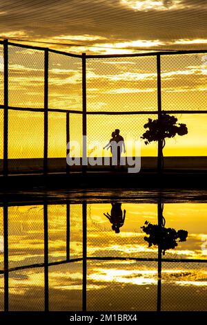 Silhouette of people exercising on the edge of Rio Vermelho beach in ...
