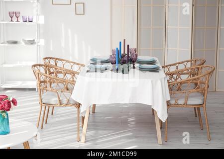 Dinnerware and eucalyptus branches on served table in light room Stock ...