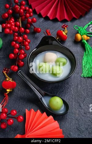 Bowl of tangyuan and Chinese decor on dark background with space for ...