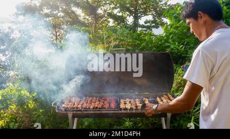 Filipino Street Food, A Filipino Man Cooking Fish On A Grill, Dinagyang ...