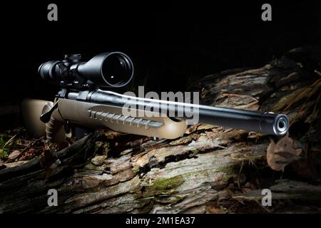 High powered riflescope on a bolt action hunting rifle in a dark forest ...