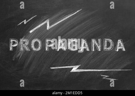 The word PROPAGANDA written in chalk on a blackboard. Information and ...