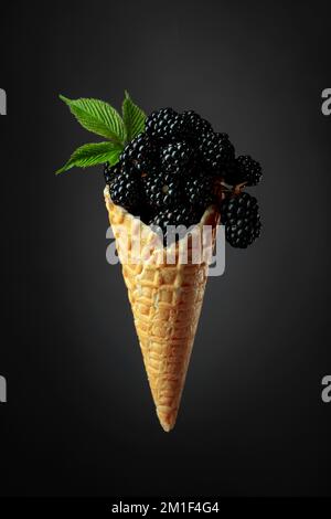 Fresh blackberries in a waffle cone on a dark blue background Stock ...