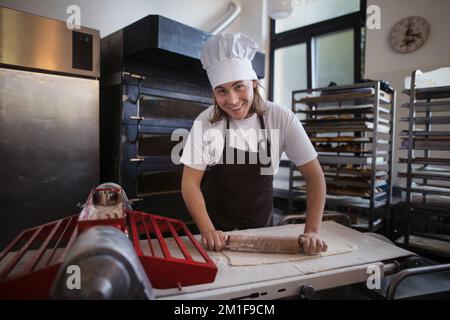 Young baker with chef cap preparing pastries in bakery Stock Photo - Alamy