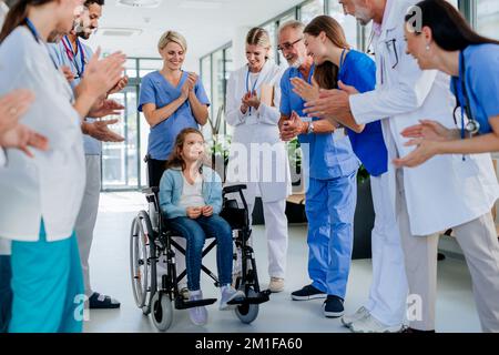 Medical staff clapping to little girl patient who recovered from ...