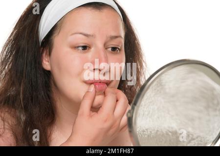 Young chubby woman checks her mouth in the mirror Stock Photo - Alamy
