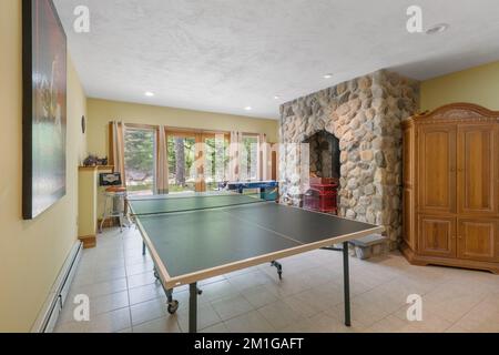 An interior shot of a room with a ping pong table, light yellow walls ...