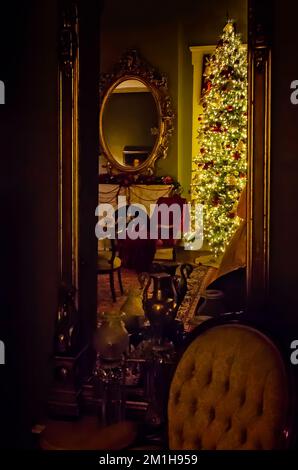 A Christmas tree is reflected in an antique mirror during Candlelight ...