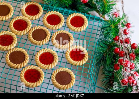 Christmas cookies with jam and hazelnut spread are cooling on wire rack ...