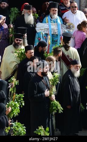A Greek Orthodox priest carrying a silver icon of the Virgin Mary ...