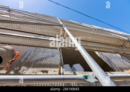 Shot from bellow on scaffolding mounted next to building under ...