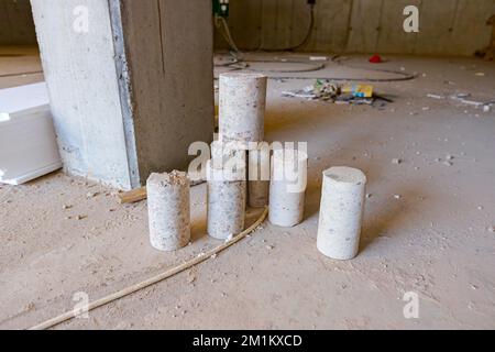 A few concrete cylindrical pillars placed on the floor of building ...