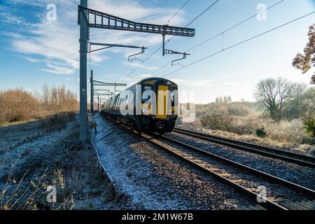 An electric GWR train on a frozen frosty track travelling to London ...