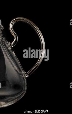 Beautiful transparent glass teapot handle close-up isolated on black ...