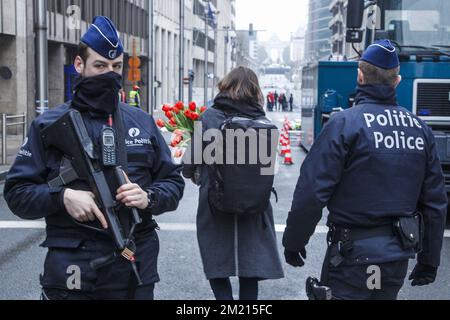 A woman holding flowers, is entering the security perimeter with a ...
