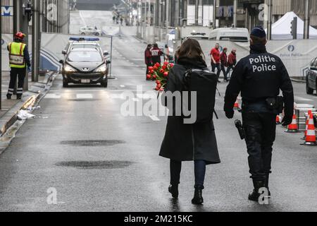 A woman holding flowers, is entering the security perimeter with a ...