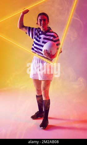 Caucasian female rugby player with ball bending over illuminated ...