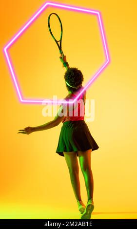 Rear view of american football player holding ball and helmet by ...