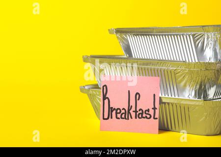 Stack of takeaway boxes and sticky note with word BREAKFAST on color ...
