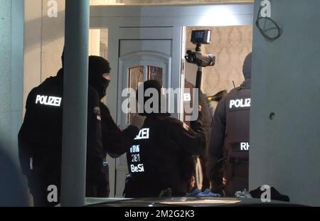 Solingen, Germany. 14th Dec, 2022. Police officers take away a suspect ...