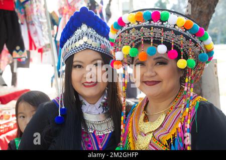 Two women in Hmong festival attire pose for a photo at the New Year ...
