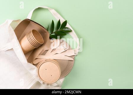 Paper utensils in white cotton bag over light green background - banner ...