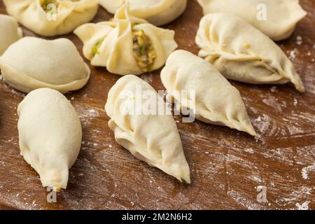 Traditional chinese dumplings in several forms and colors on a wooden ...
