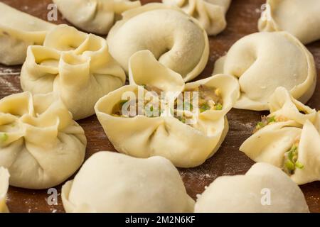 Traditional chinese dumplings in several forms and colors on a wooden ...