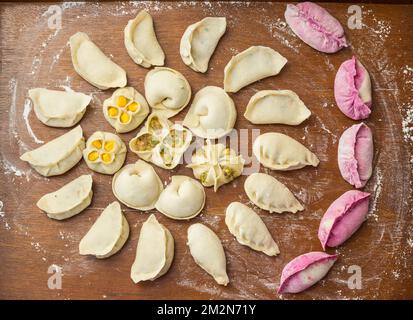 Traditional chinese dumplings in several forms and colors on a wooden ...
