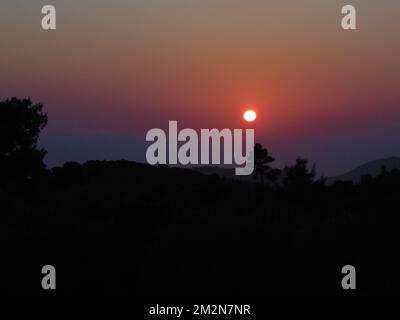 Sunset over forested hills in Dalarna on a cold winter day Stock Photo ...
