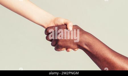 Helping hands, Rescue gesture. African and caucasian hands. Giving a ...