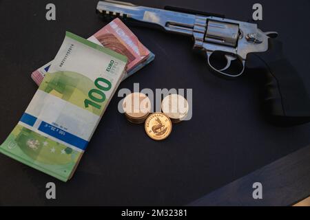 next to a wad of cash and a stack of Krugerrand gold coins lies a ...