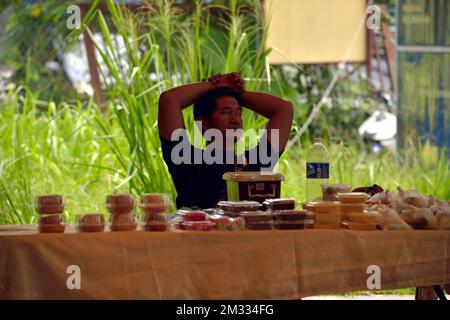 An indigenous Bajau man selling food at the Sunday market (tamu) in ...