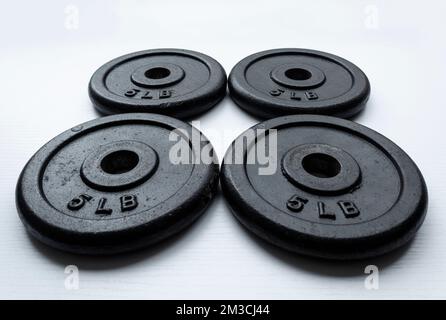 Closeup to a four dumbbell disc of 5 pounds over white background ...