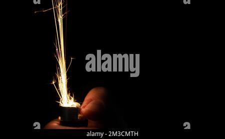 Closeup to hand igniting fire lighters with black background. Energy ...