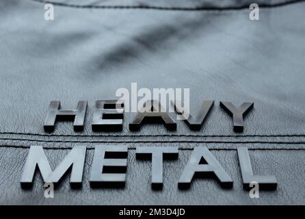 Closeup to a HEAVY METAL black lettering word over a black leather ...