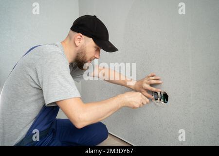 Electrician working safely on switches and sockets of household ...