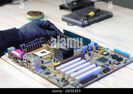 inserting ram into motherboard from computer on table and gray ...