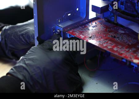 inserting an old graphics card into a computer on the table Stock Photo ...