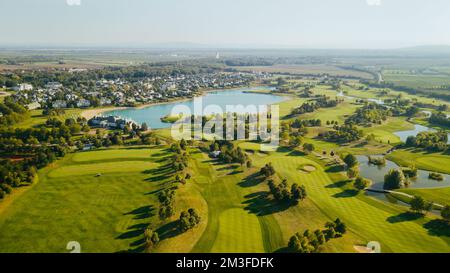 A drone view of water bodies surrounded by greenery and buildings in ...