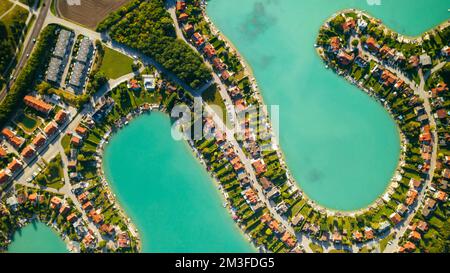 A drone view of water bodies surrounded by greenery and buildings in ...