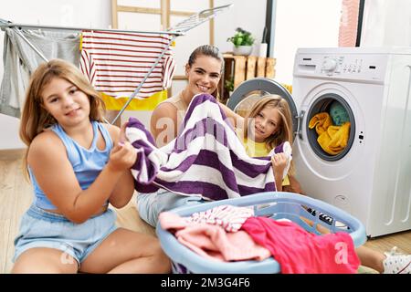 Mother and daughters washing clothes smelling towel at laundry room Stock Photo - Alamy