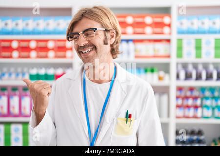 Caucasian man with mustache working at pharmacy drugstore smiling with ...