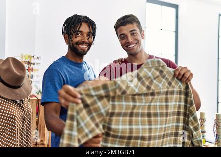 Two men friends choosing clothes holding shirt at clothing store Stock ...