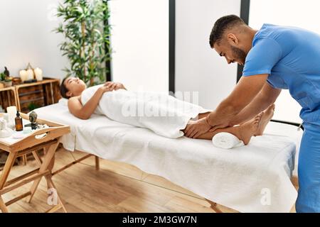 Latin man and woman wearing physiotherapy uniform having rehab session ...