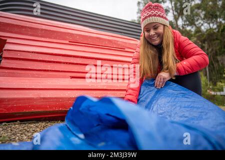 folding up a blue tarp after camping at a music festival in australia ...