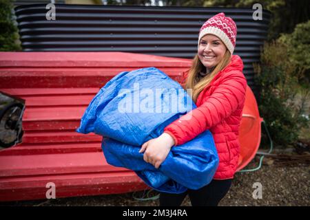 folding up a blue tarp after camping at a music festival in australia ...