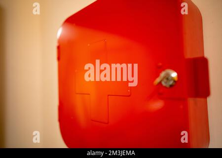 red first aid kit mounted to the wall full of supplies. red first aid ...